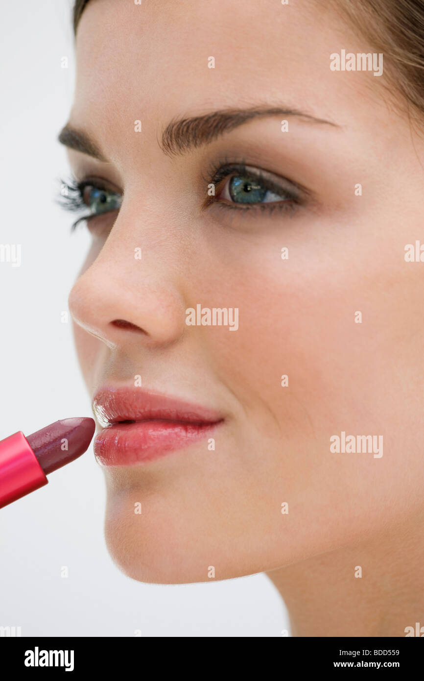 Fashion model applying lipstick on her lips Stock Photo - Alamy