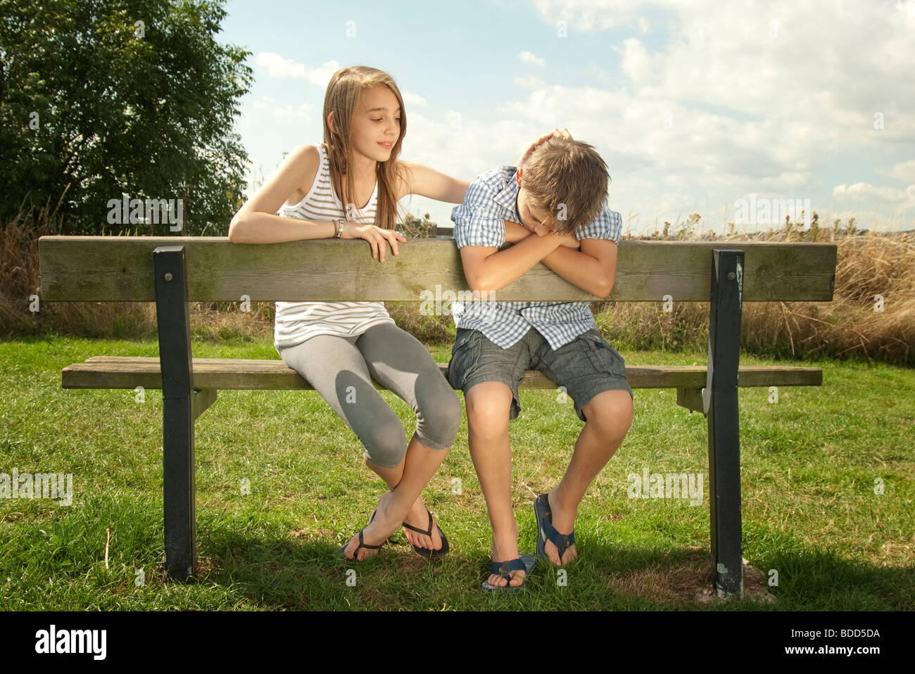 brother & sister sitting on bench Stock Photo - Alamy