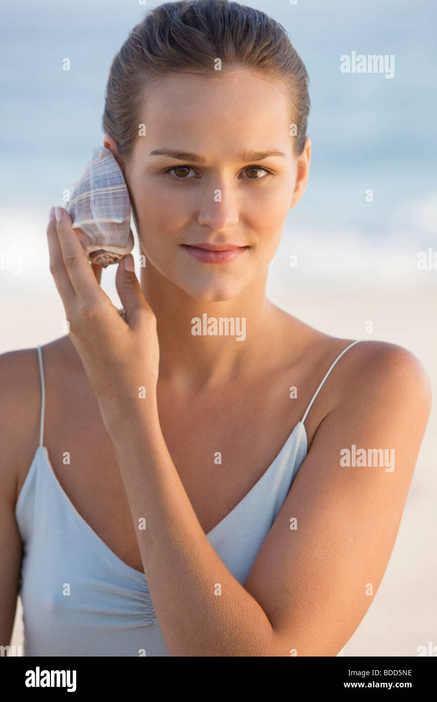 Woman listening to a conch shell Stock Photo - Alamy