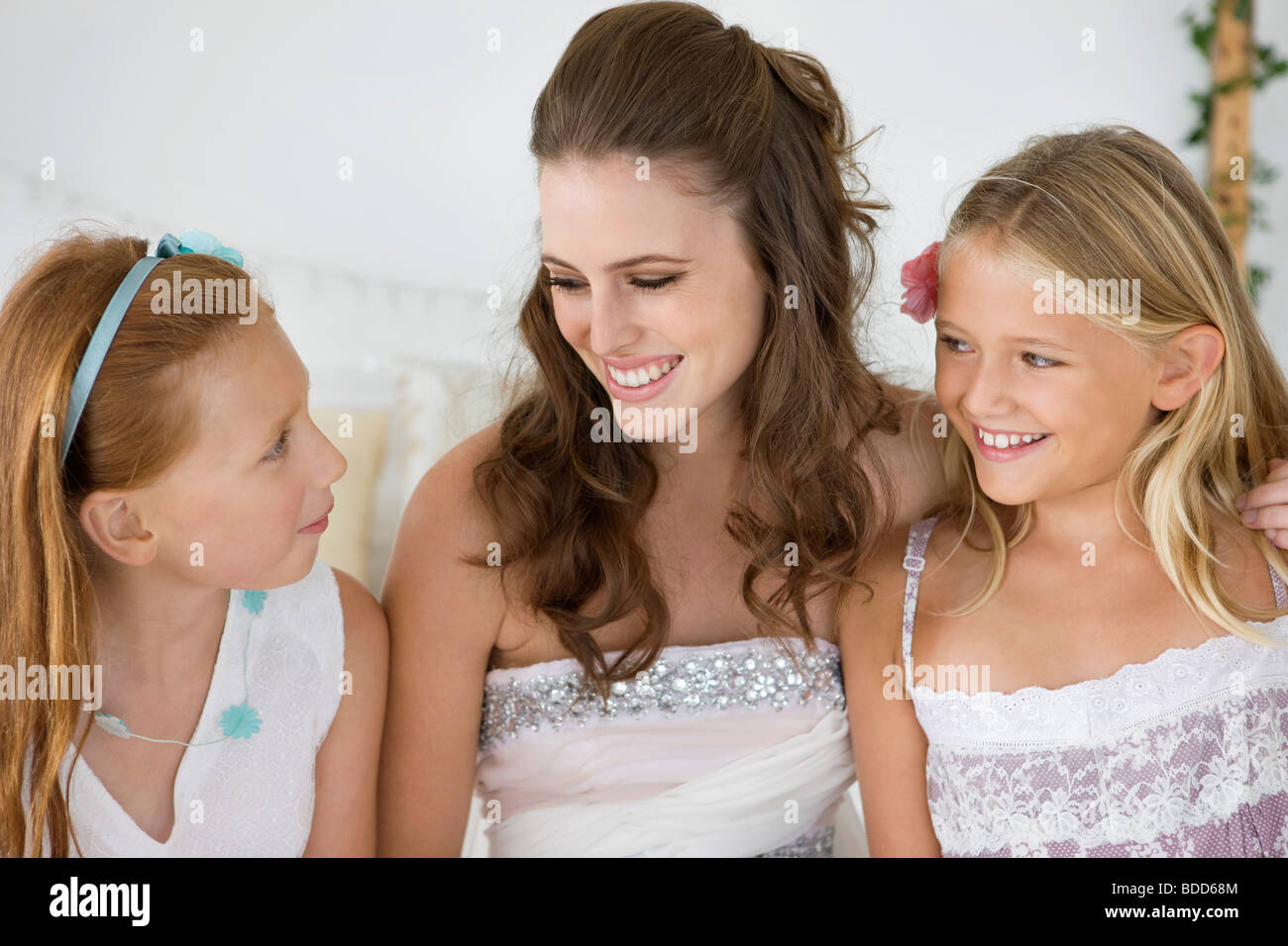 Bride sitting with two girls Stock Photo - Alamy