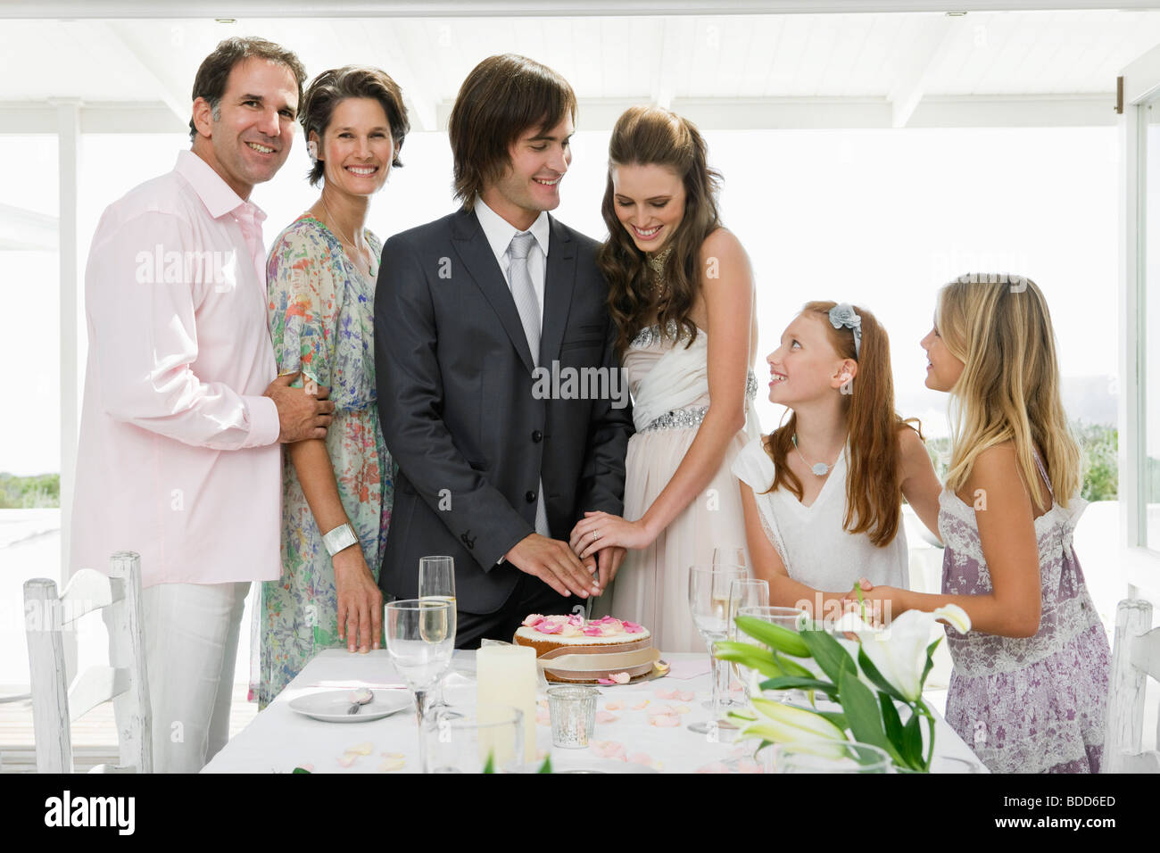 Newlywed couple with guests in a wedding party Stock Photo - Alamy