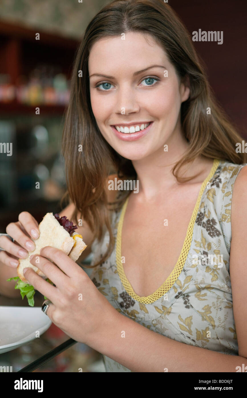 Woman eating sandwich in a cafe Stock Photo - Alamy