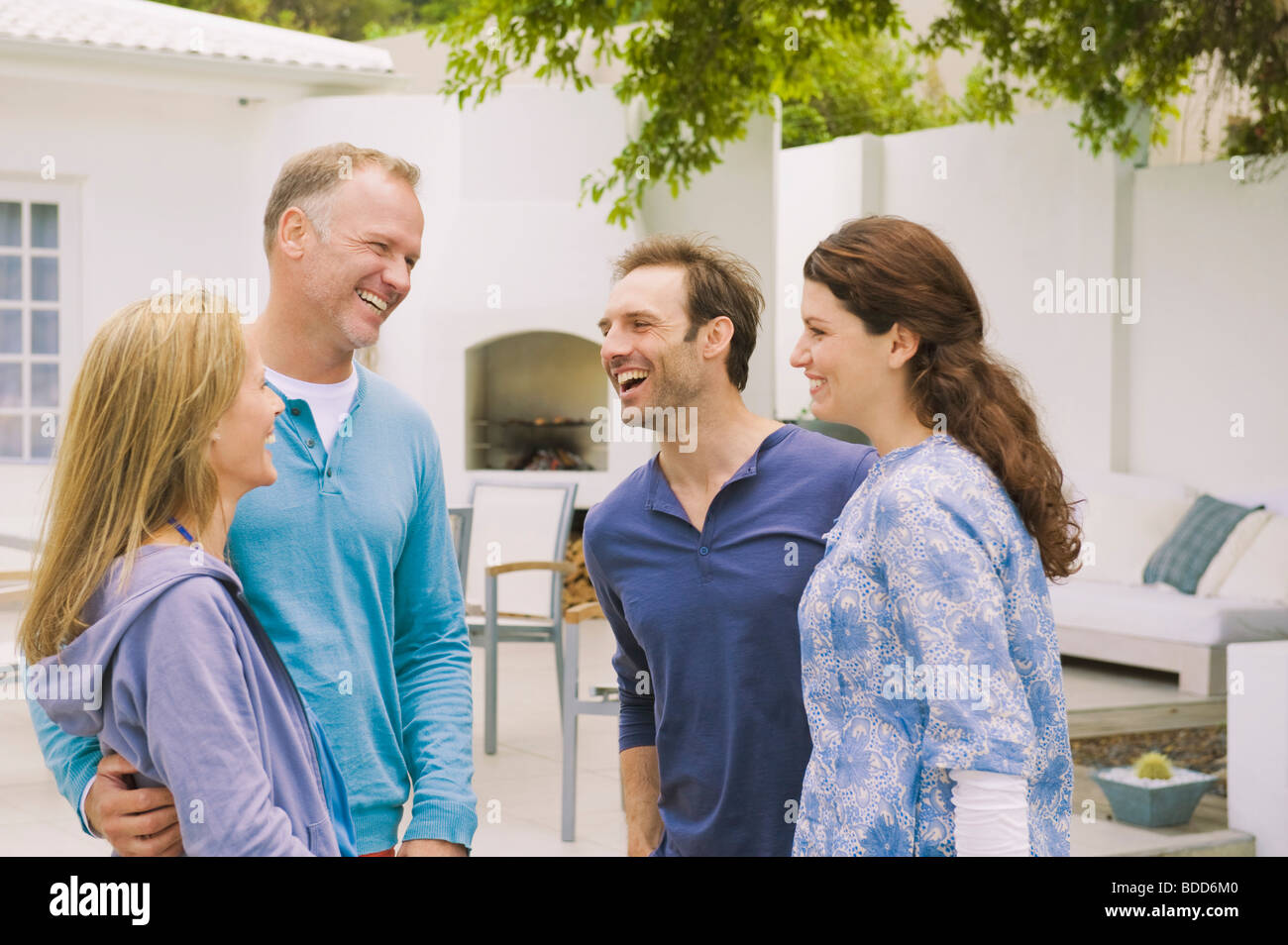 Two couples smiling together Stock Photo - Alamy