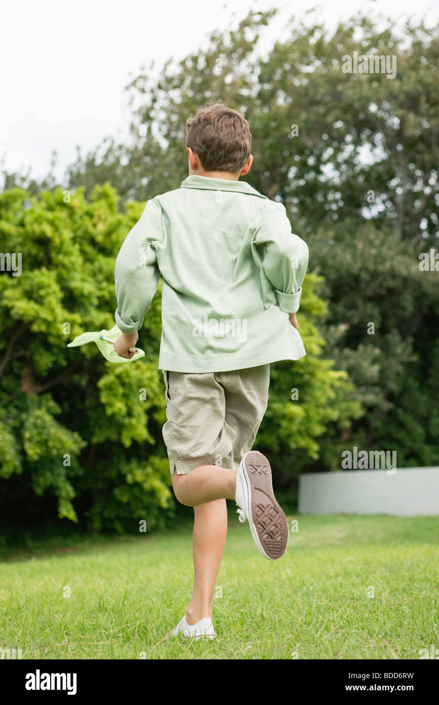 Boy running in a garden with a butterfly net Stock Photo - Alamy
