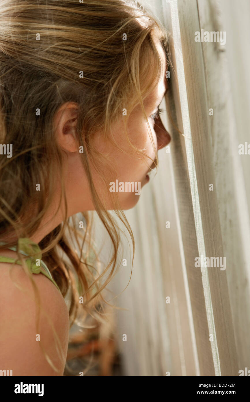Girl peeking through a fence Stock Photo - Alamy
