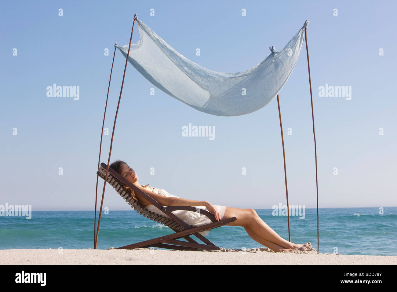 Woman resting in a deck chair under a canopy Stock Photo - Alamy