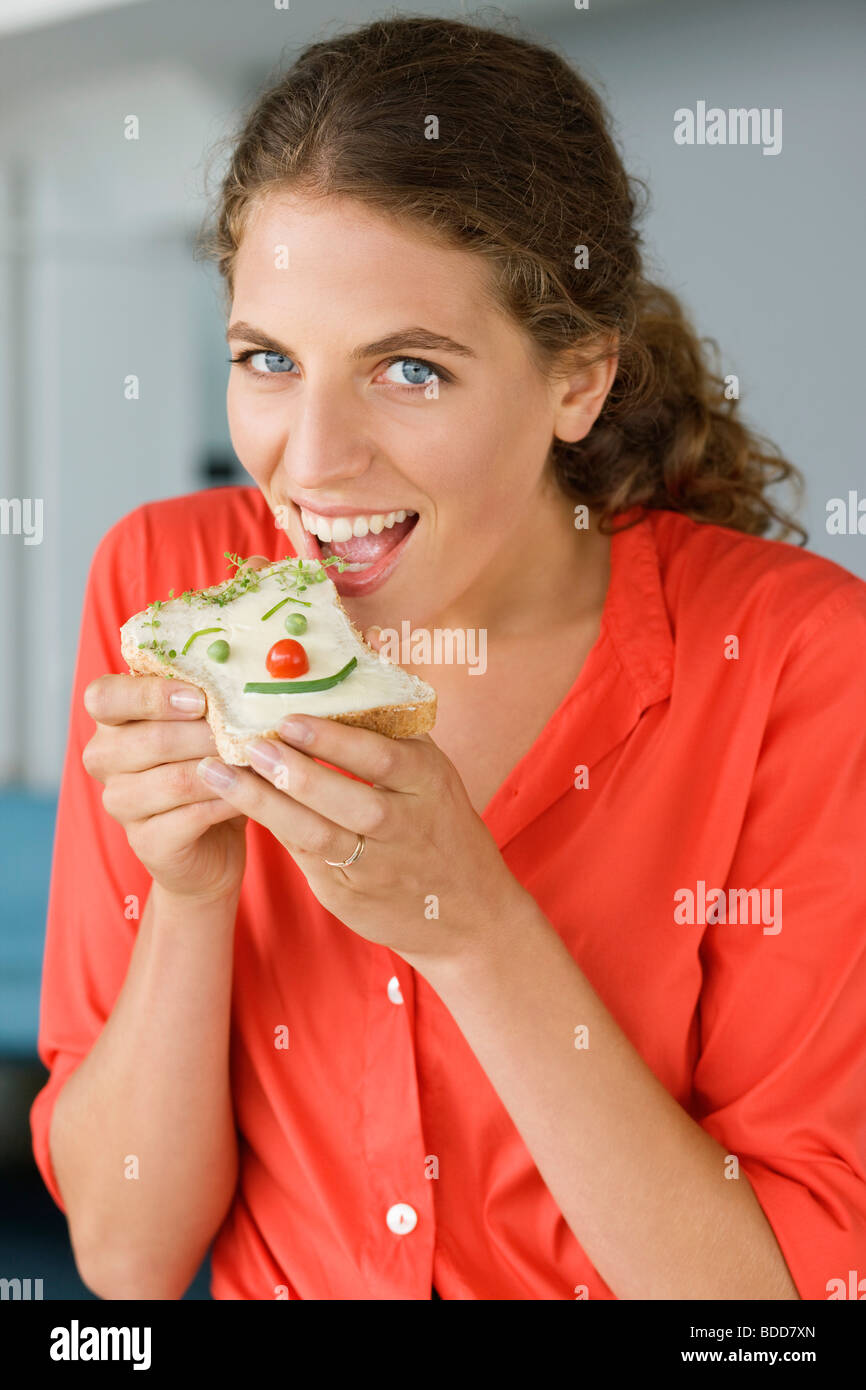 Portrait of a woman eating sandwich Stock Photo - Alamy