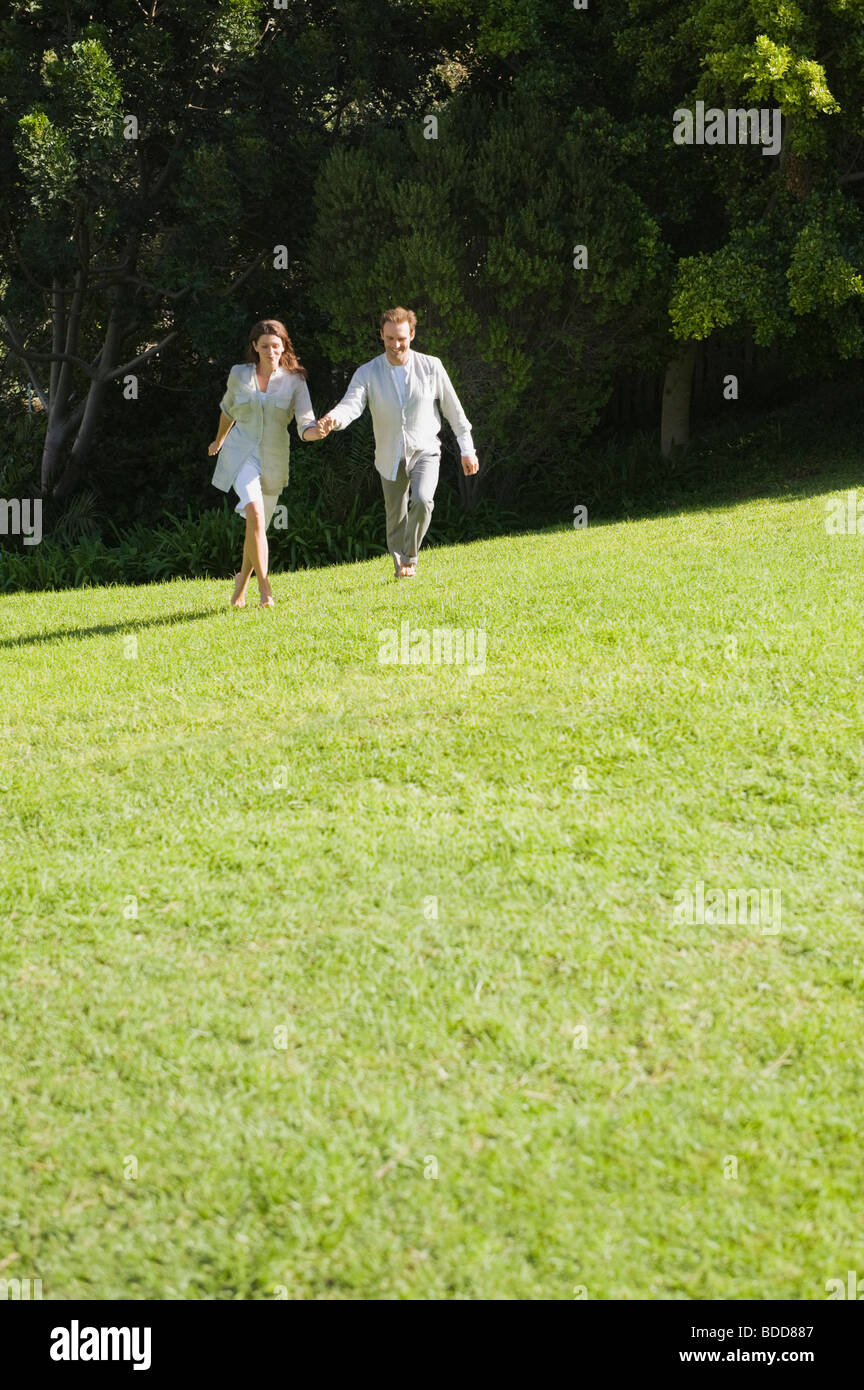 Couple running on grass Stock Photo - Alamy
