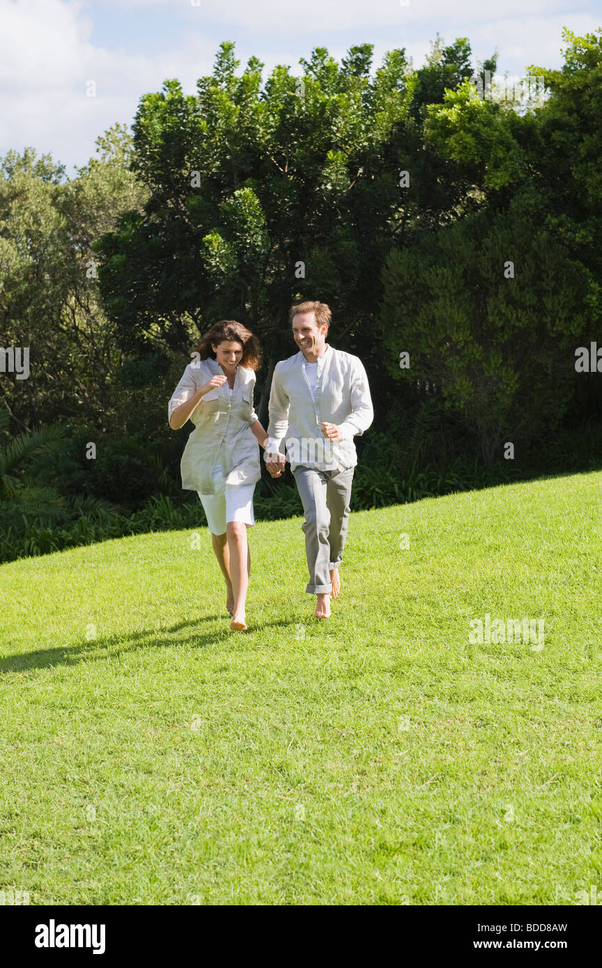 Couple running on grass Stock Photo - Alamy
