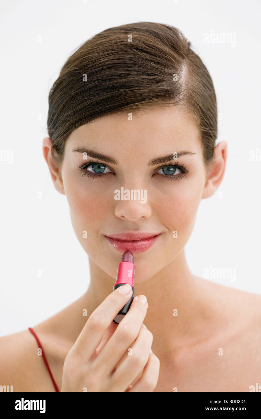 Fashion model applying lipstick on her lips Stock Photo - Alamy