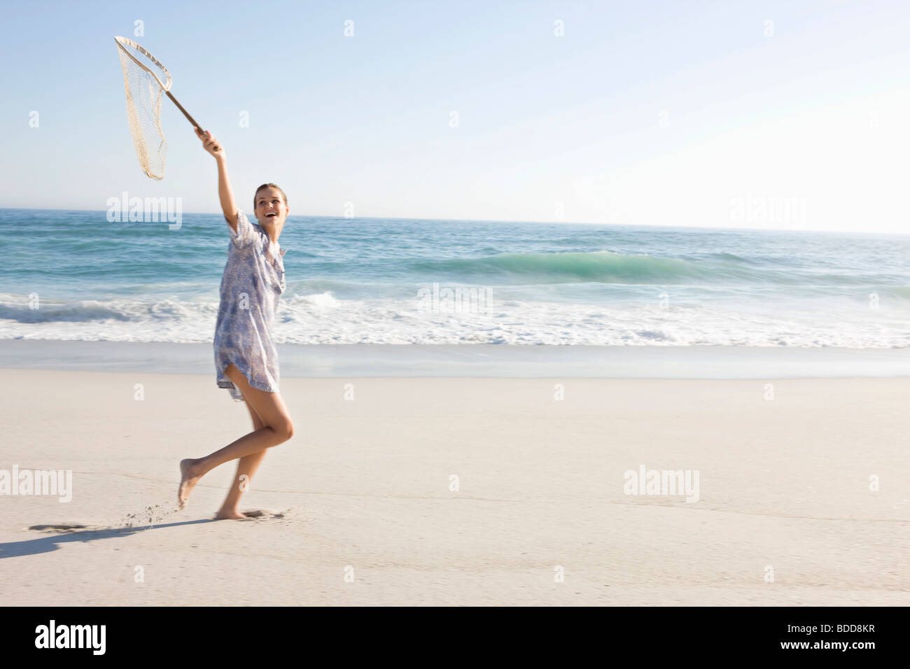 Woman carrying a fishing net on the beach Stock Photo - Alamy