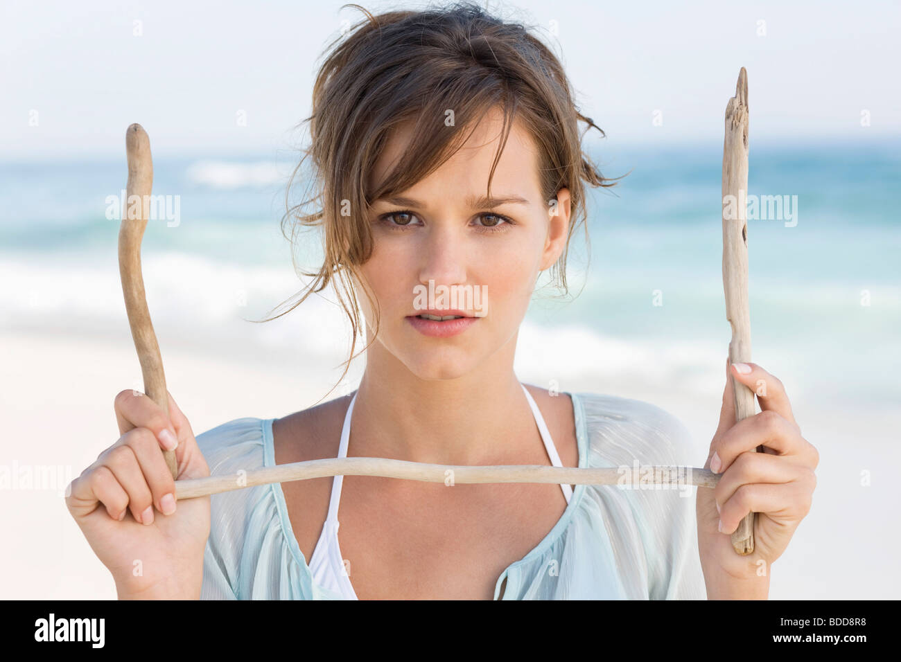 Portrait of a woman holding sticks Stock Photo - Alamy
