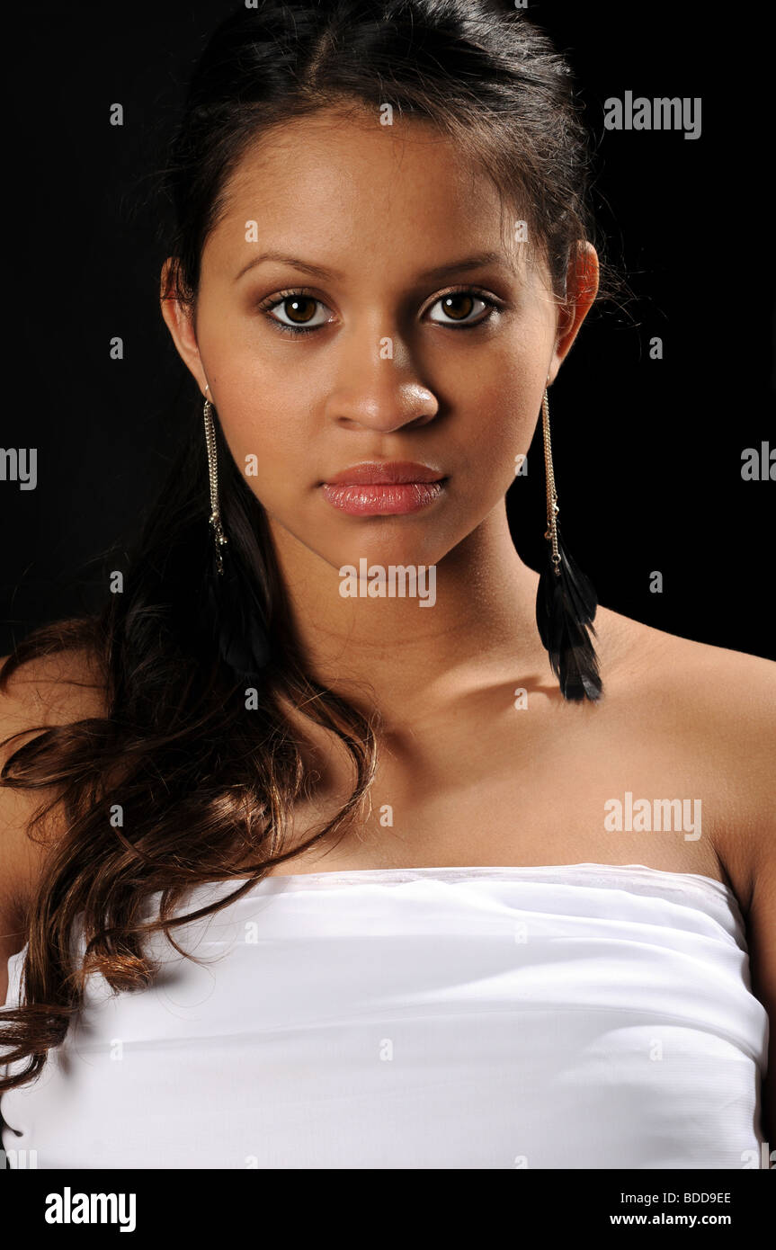 Portrait of beautiful Hispanic woman looking into camera over a dark ...