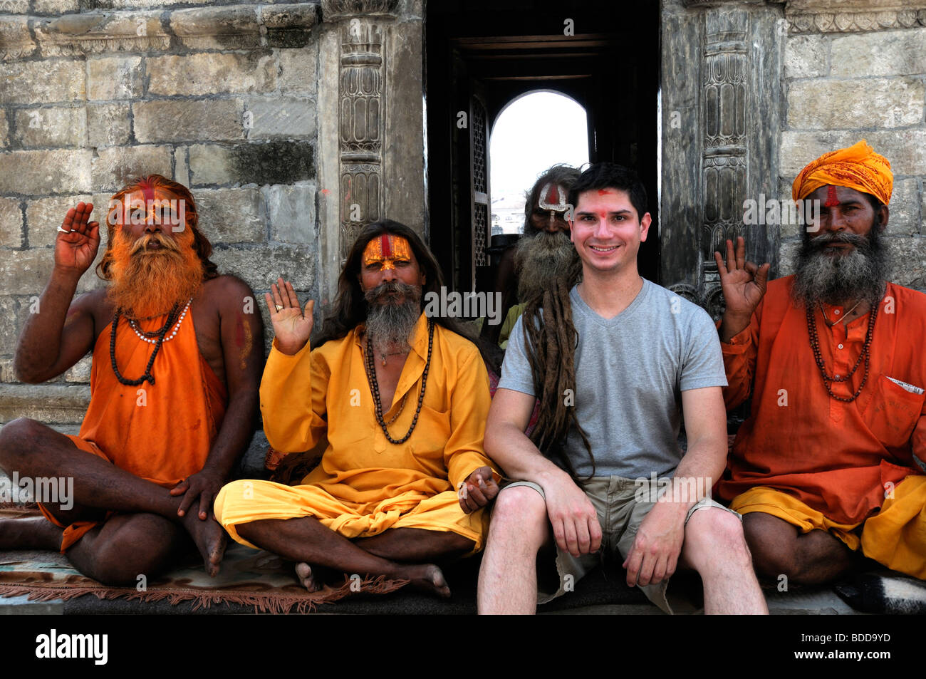 tourist posing for photograph with Sadhu holy men painted ash and body ...