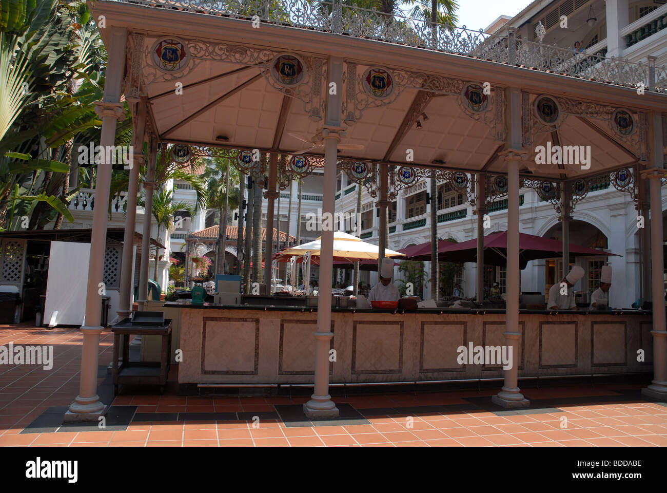 3 chefs working at outdoor restaurant kitchen, Raffles Courtyard ...