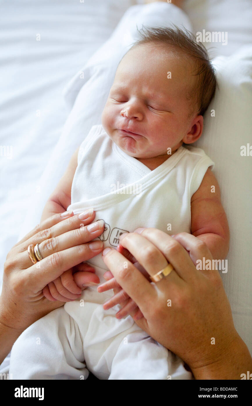 Sleeping newborn baby on mothers lap Stock Photo - Alamy
