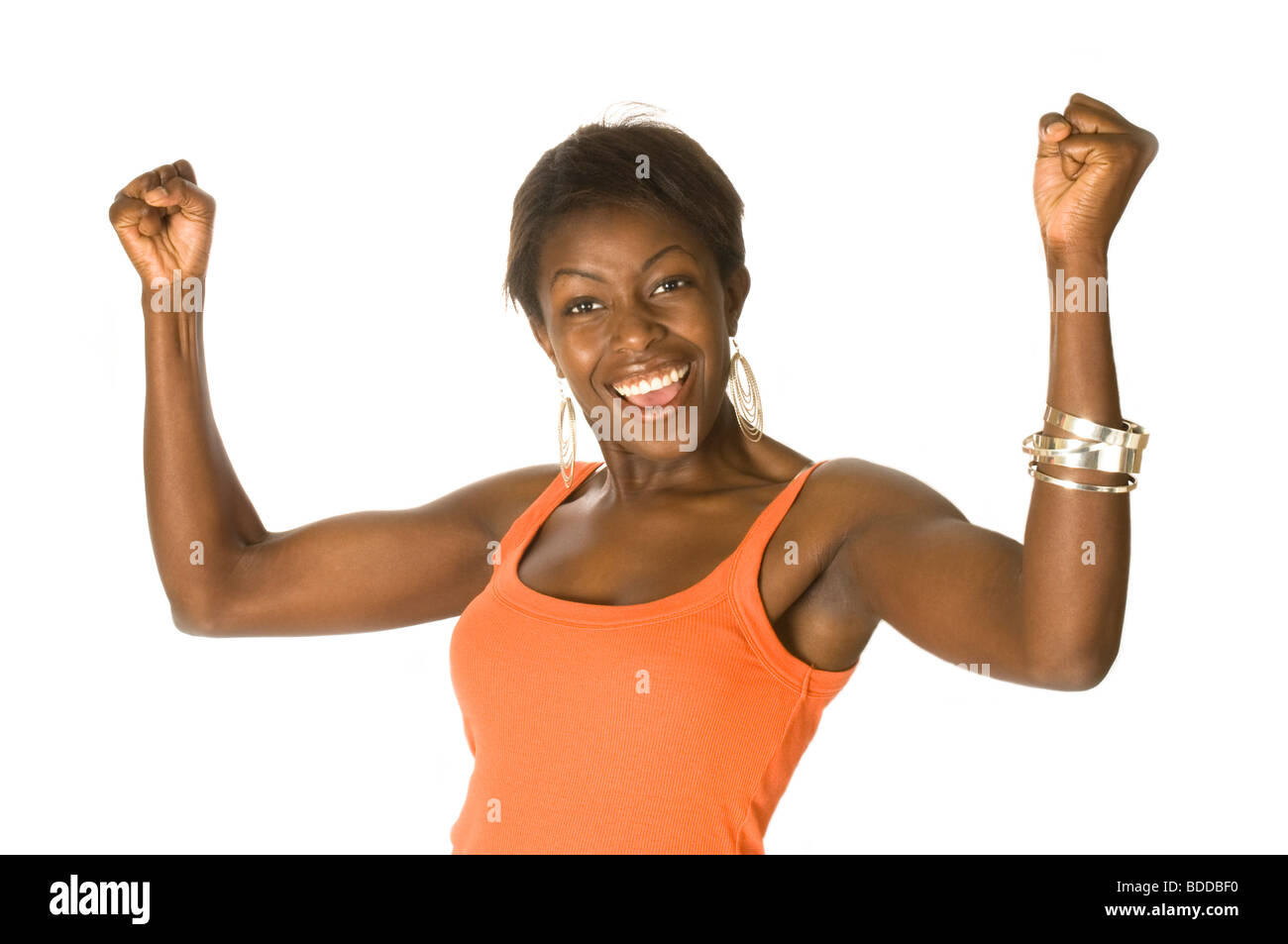 Studio portrait of a happy attractive young African woman with arms in ...
