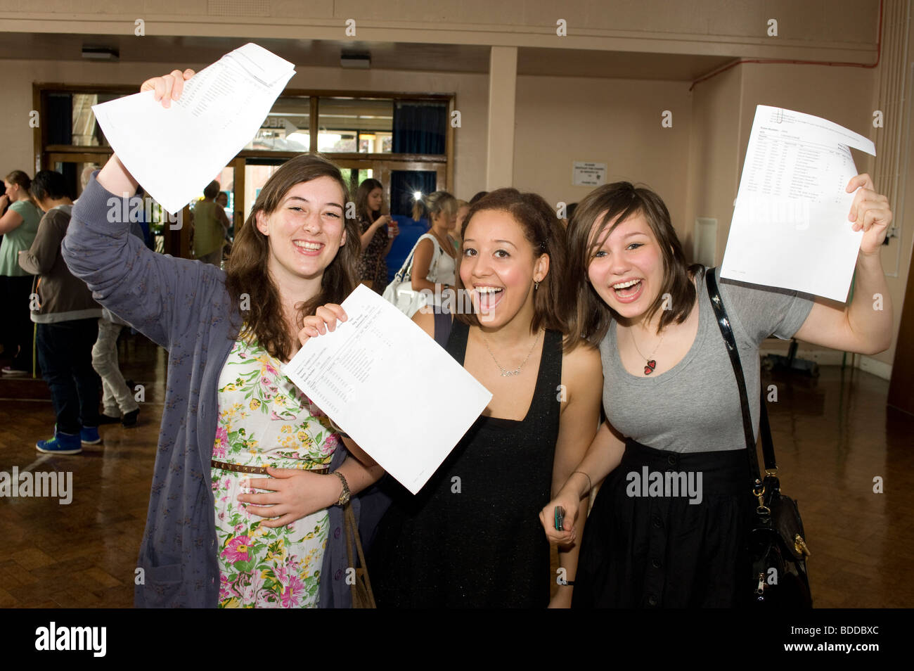 Three happy teenage girls waving their GCSE A Level exam results to ...