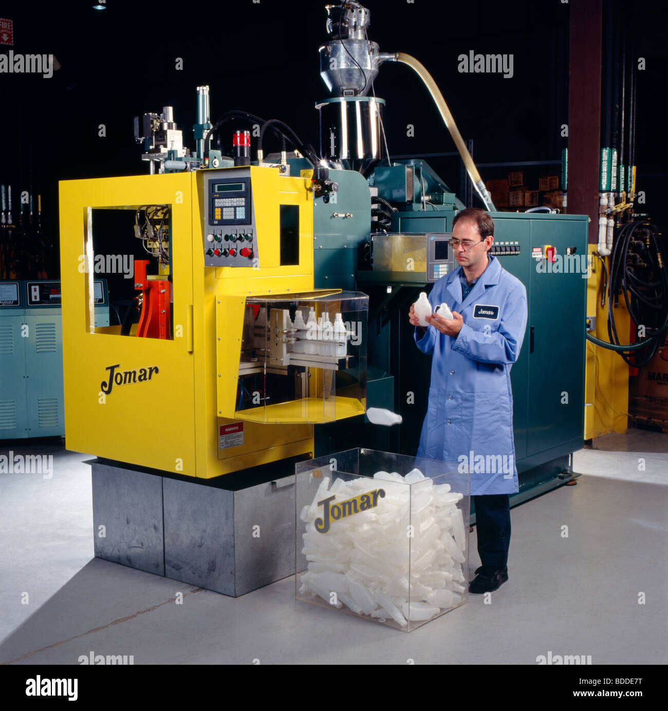 Extrusion blow molding machinery makes plastic containers Stock Photo ...