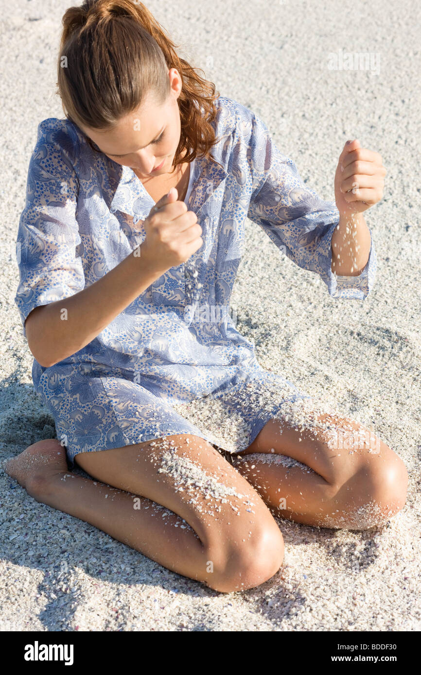 Woman playing with sand on the beach Stock Photo - Alamy