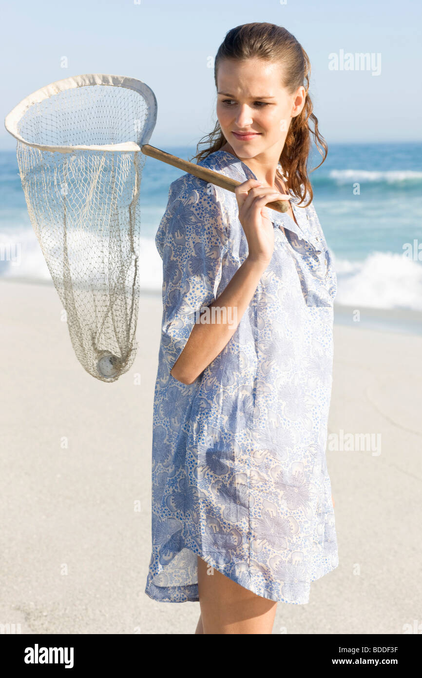 Woman carrying a fishing net on the beach Stock Photo - Alamy