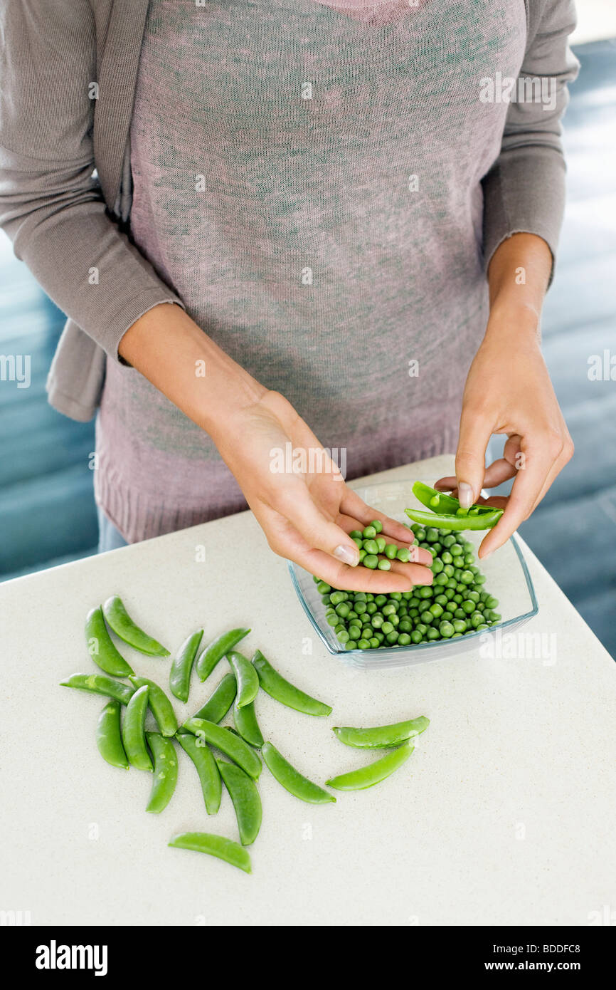 Woman peeling green peas in the kitchen Stock Photo - Alamy