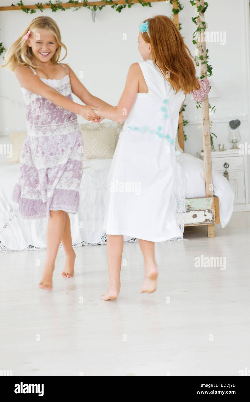 Two flower girls playing in a bedroom Stock Photo - Alamy