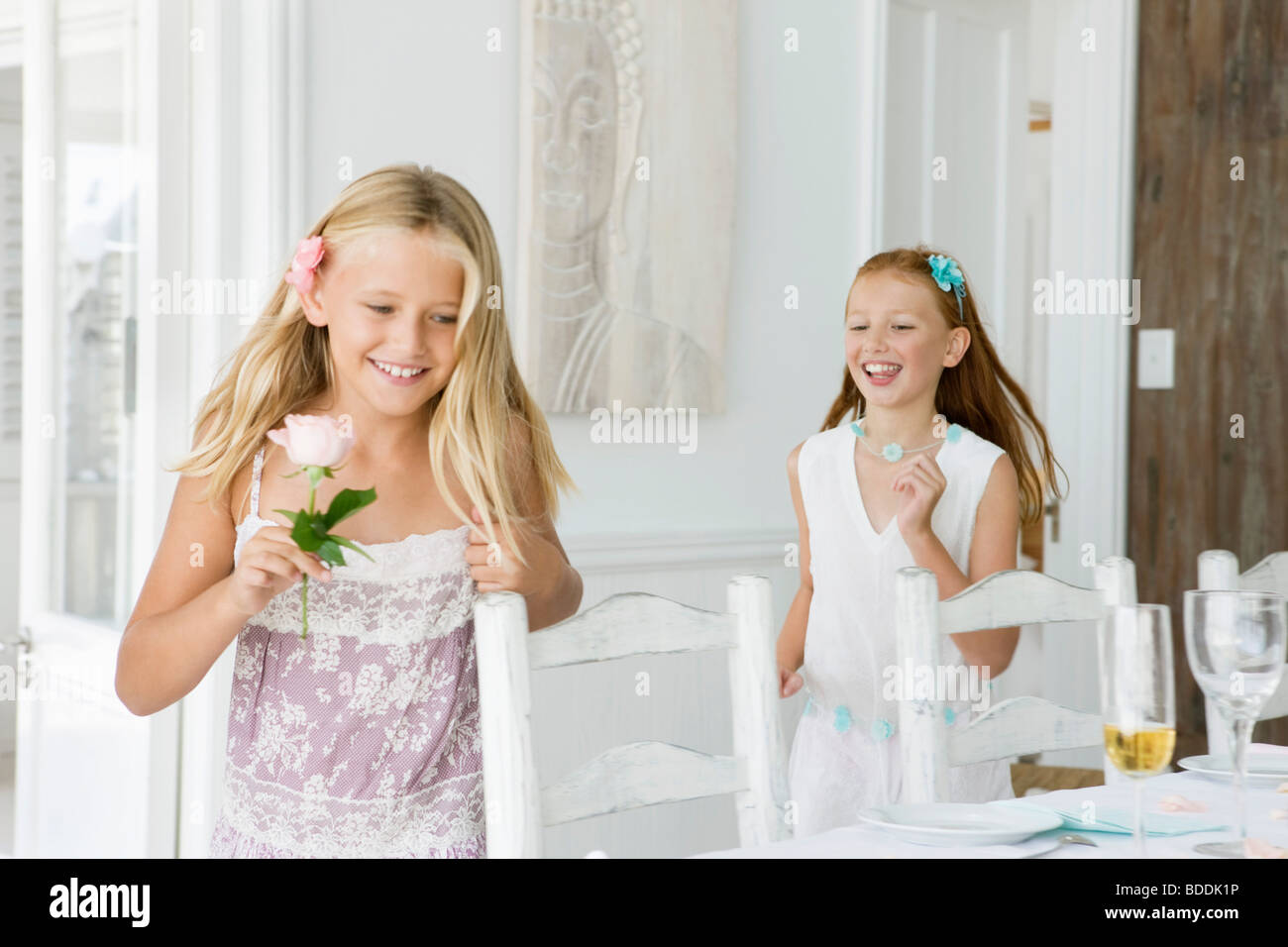 Two girls playing at a dining table Stock Photo - Alamy