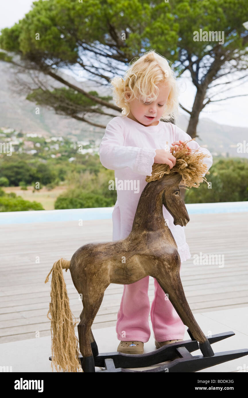 Girl playing with a rocking horse Stock Photo - Alamy