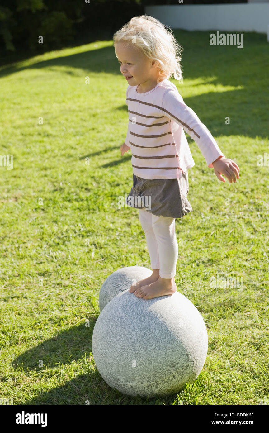 Girl standing on a round stone Stock Photo - Alamy