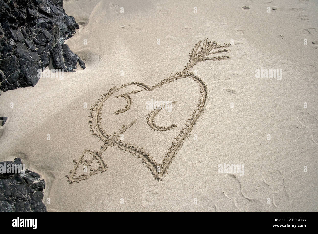 Heart and initials drawn in sand Stock Photo - Alamy