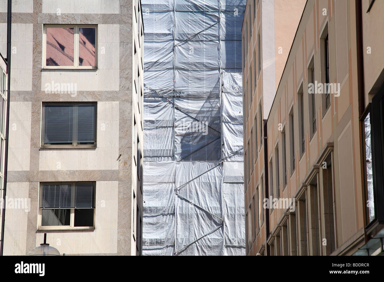 Plastic covered scaffolding on a building site in Munich, Germany Stock ...