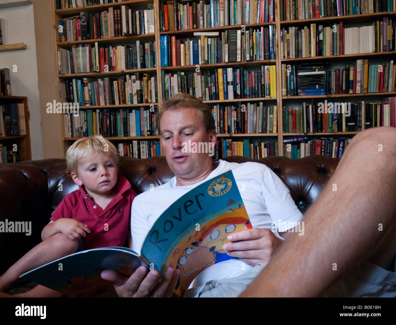 Father reading book to young son in bookshop Stock Photo - Alamy