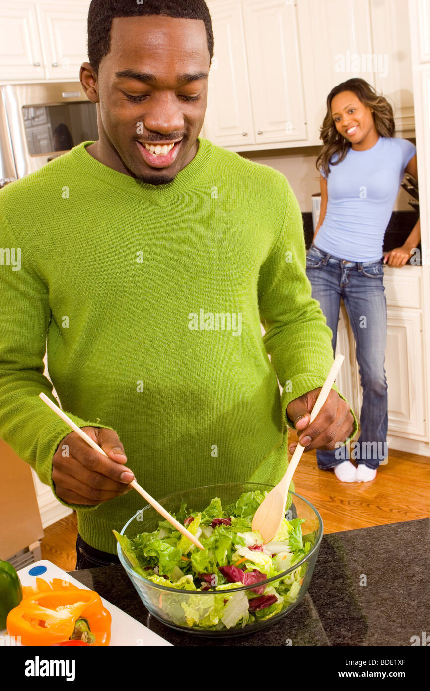 Couple in kitchen making a salad Stock Photo - Alamy