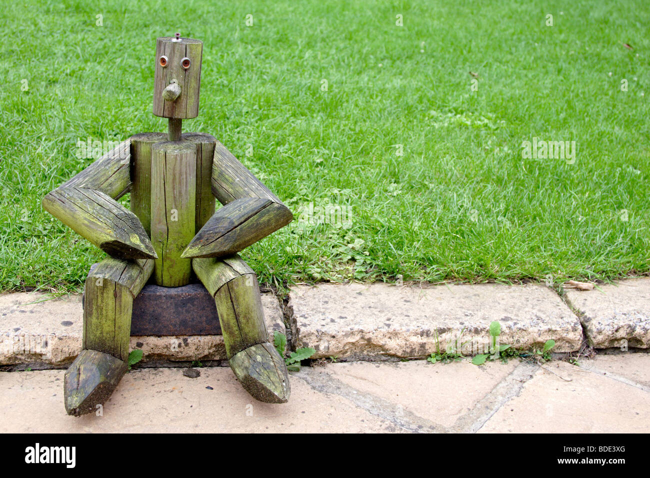 Wooden figure sitting in garden England UK Stock Photo - Alamy