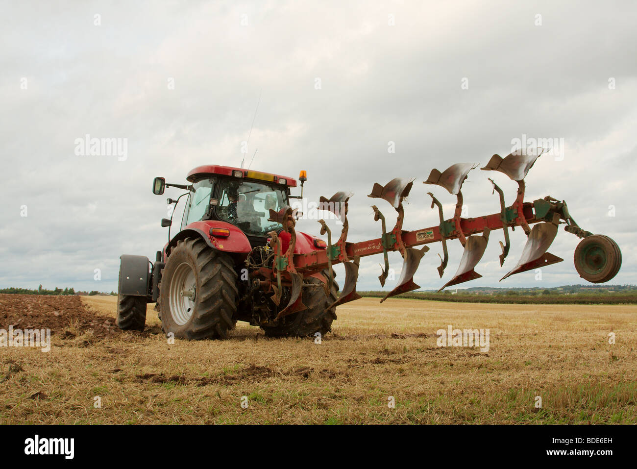 large tractor ploughing in stubble after harvest Stock Photo - Alamy