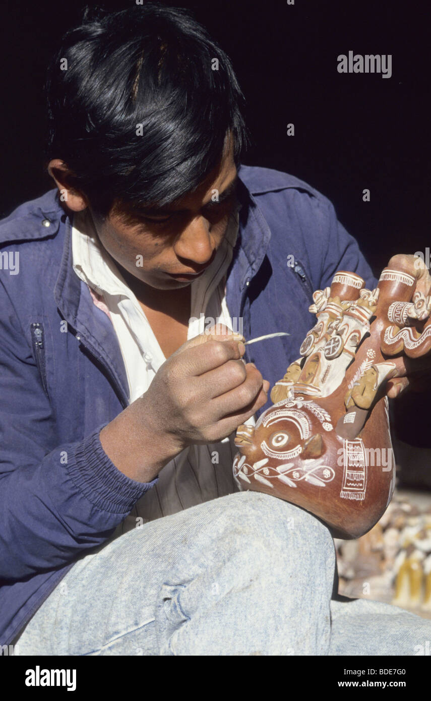 Indigenous Indians from Quinua, central Peru painting a typical pot ...