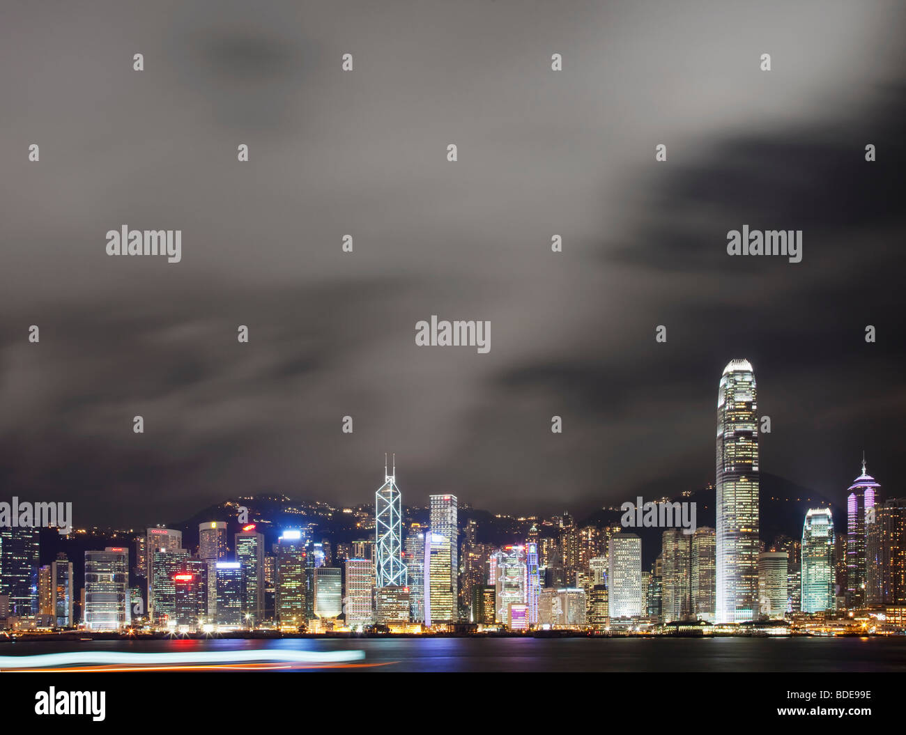 View across Victoria Harbour of high rise buildings at night in Hong ...