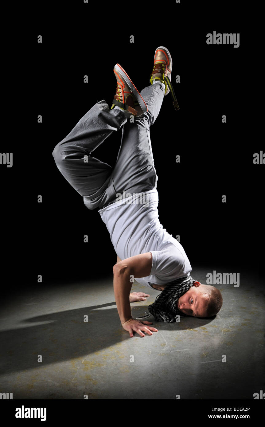 Young breakdancer performing free-style dancing over dark background ...