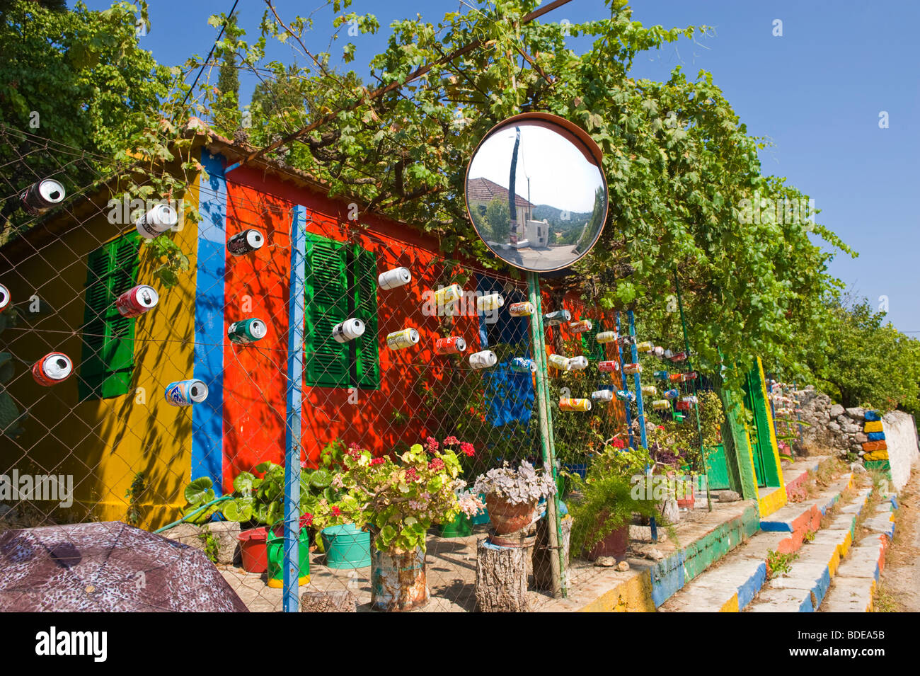 Colourful eccentric house with empty drinks cans decorating fence at ...