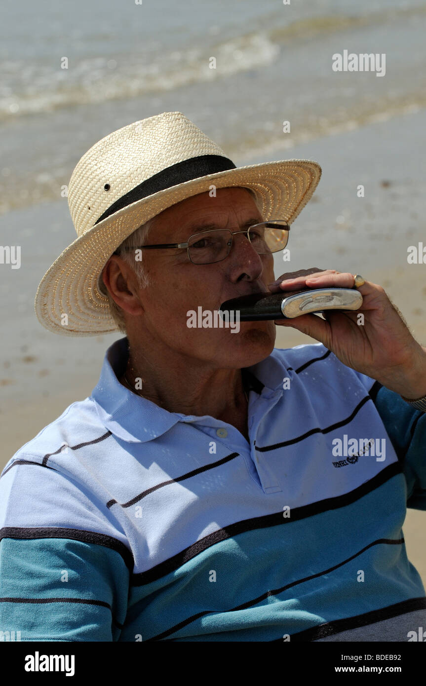 Portrait of a man drinking from a hip flask Stock Photo - Alamy