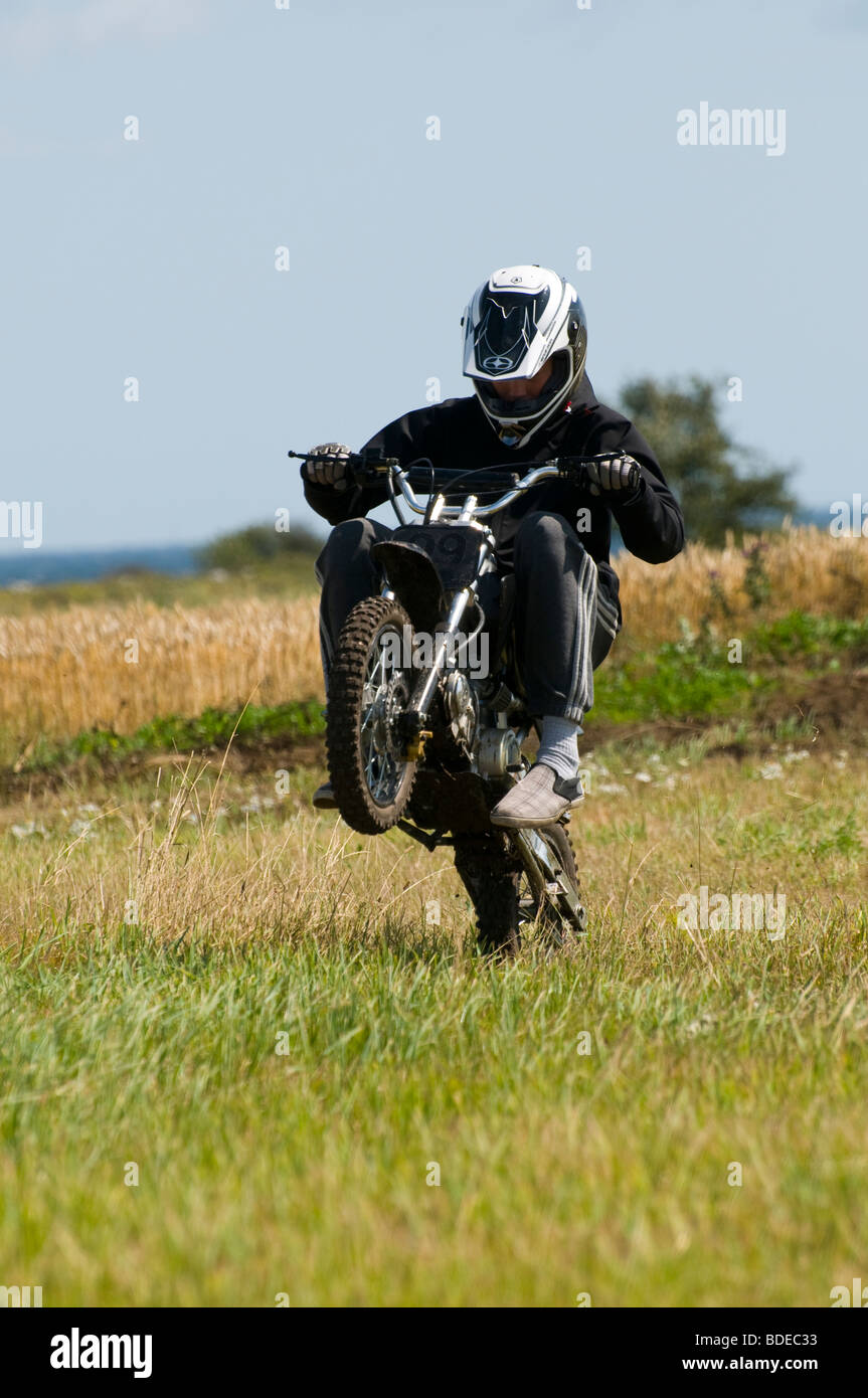 Dirtbike driver on a field by the sea Stock Photo - Alamy