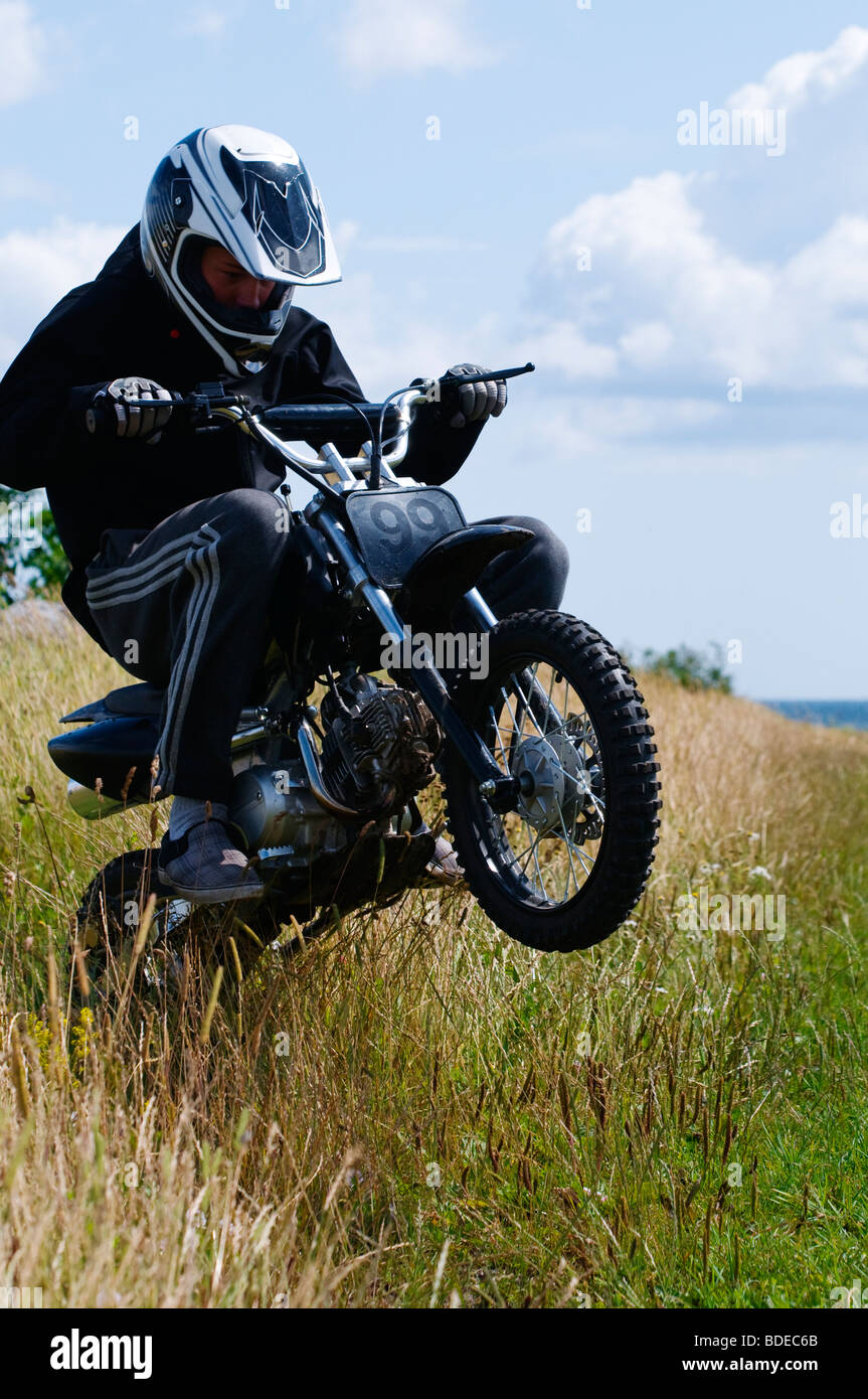 Dirtbike driver on a field by the sea Stock Photo - Alamy