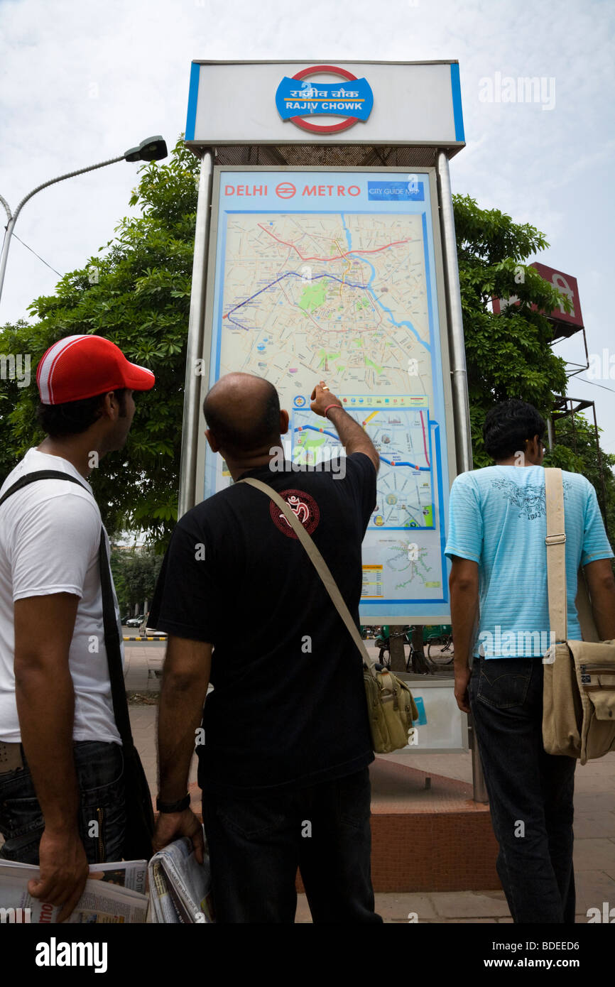 Indian men look at an information route map of the Delhi Metro system ...