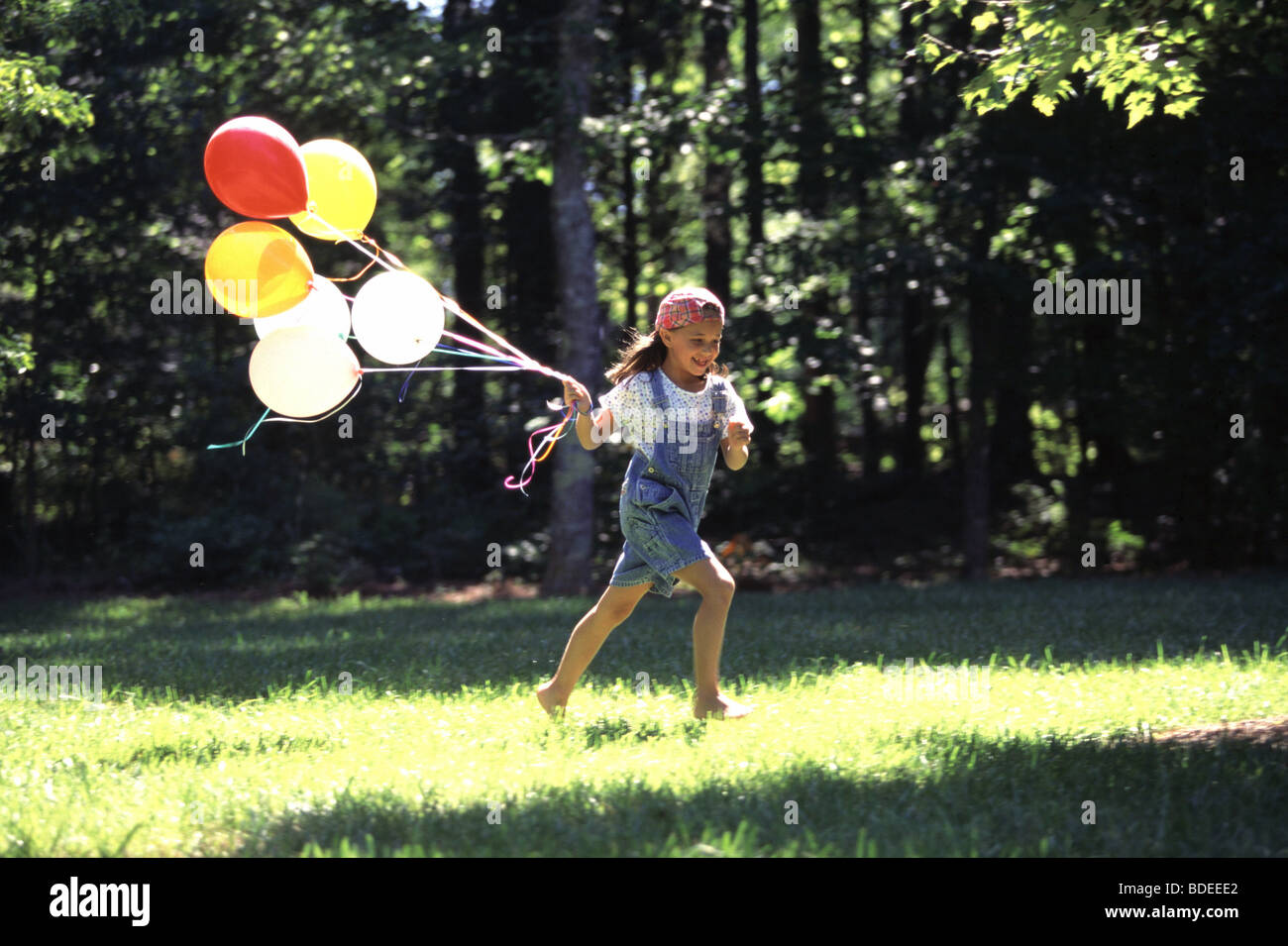 Girl running with balloons Stock Photo - Alamy