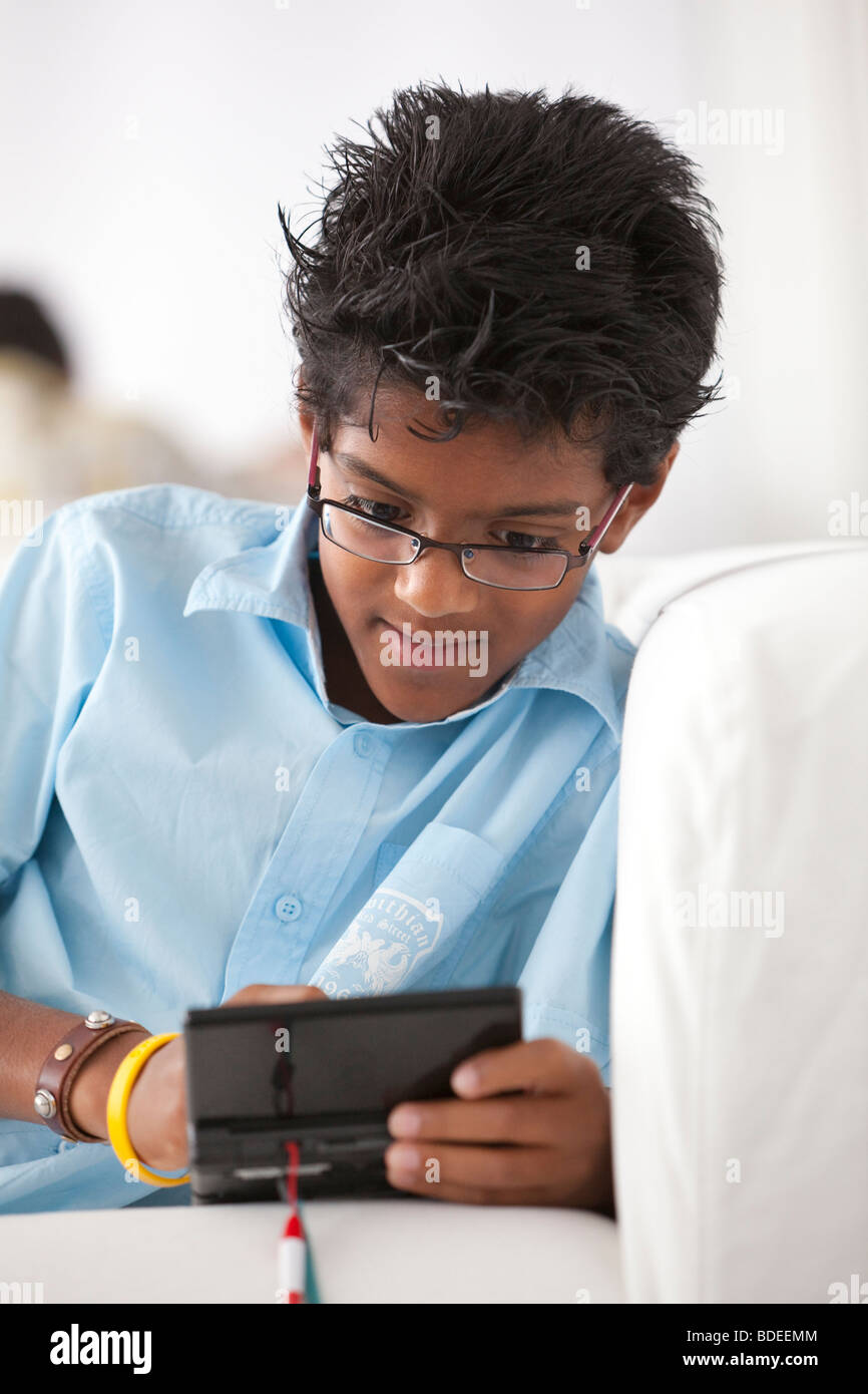 Teenage boy is playing on a gameboy Stock Photo - Alamy