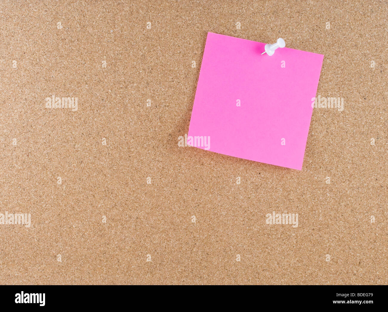 Pink sticky note attached to a corkboard Stock Photo - Alamy