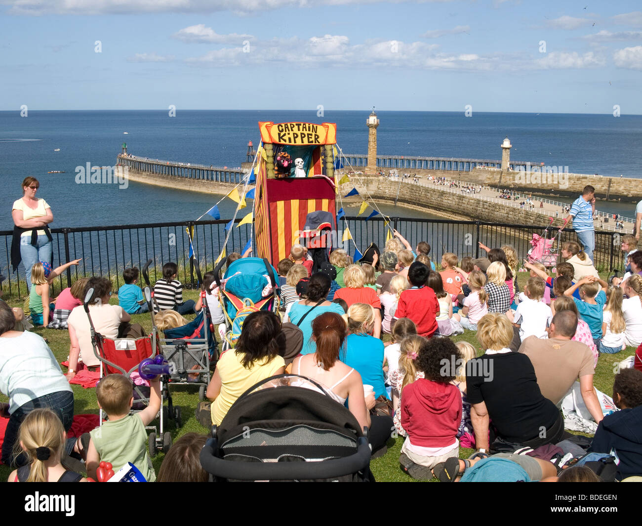 Parents and children watching Captain Kipper a seaside "Punch and Judy ...