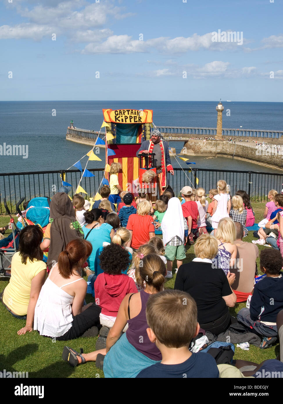 Parents and children watching Captain Kipper a seaside "Punch and Judy ...