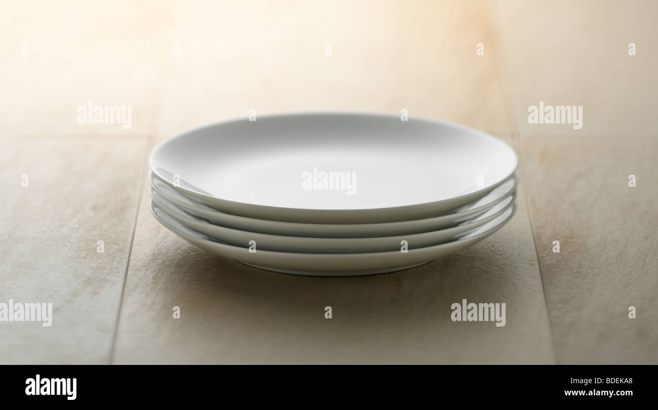 White dinner plates sitting on work surface Stock Photo - Alamy